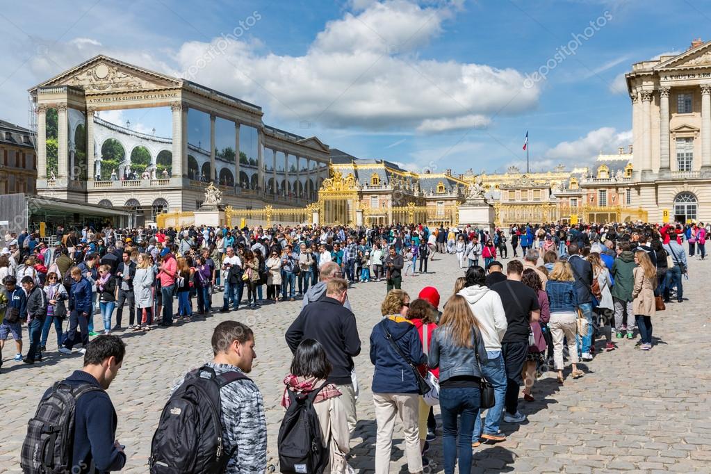 Visitors waiting in long queues to visit the Palace of Versailles ...