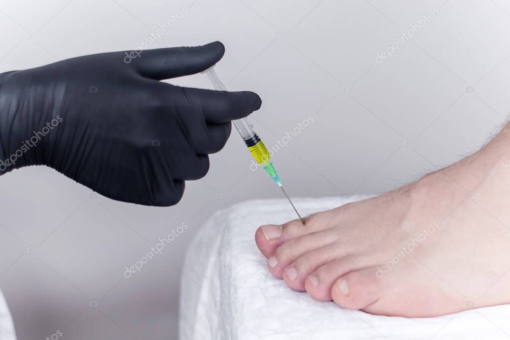 Un cirujano ortopédico administra una inyección en la articulación del ...