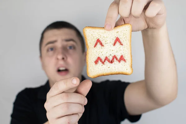 Conceptually about gluten intolerance. The man holds in his hand a ...