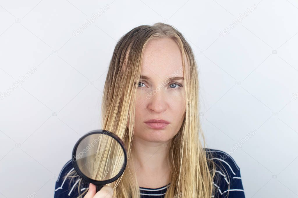 La chica mira delante de la lupa su cabello graso. cuero cabelludo ...