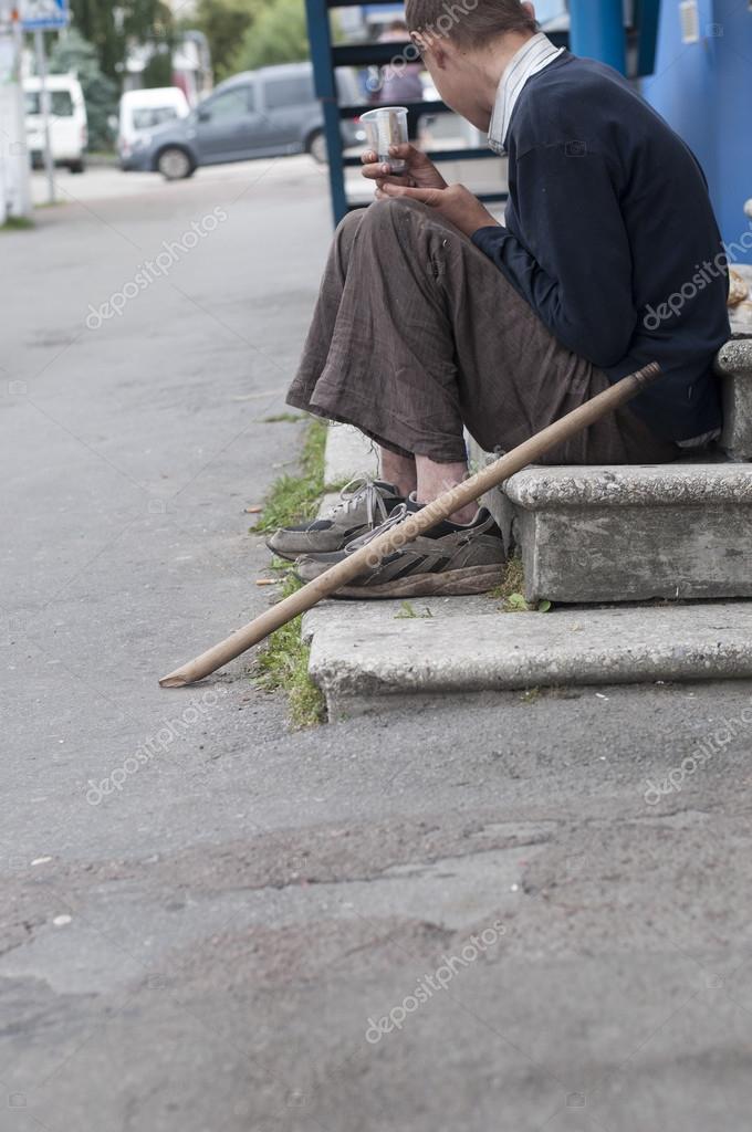 Niño sin hogar sentado en la calle y pidiendo ayuda: fotografía de ...