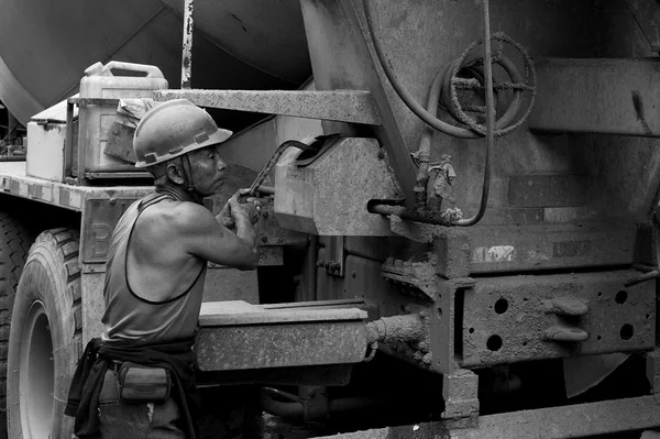 Hardworking laborer and truck-concrete mixer on construction site ...