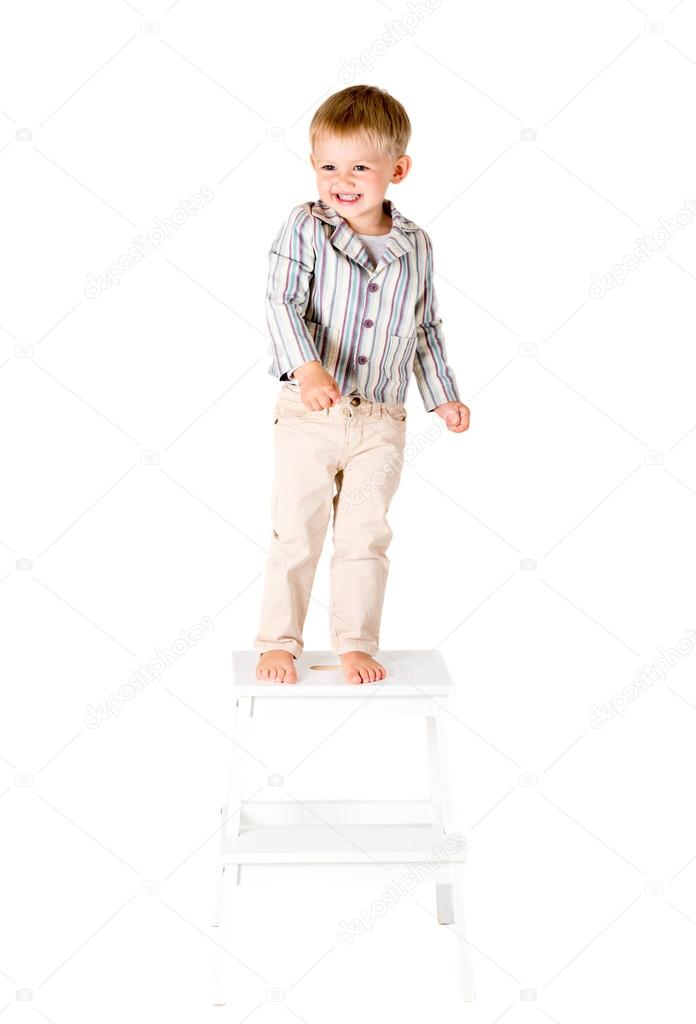 Boy standing on stool Stock Photo by ©Nanisimova_sell 69009689