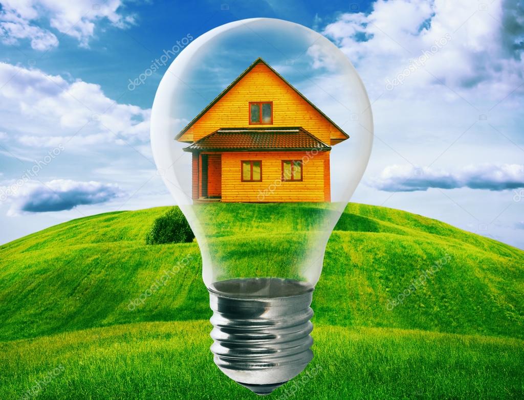 Light bulb with a house standing inside in green field. Eco tech Stock ...