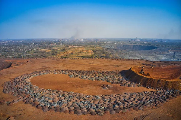 Huge mounds of waste iron ore near the quarry. Belaz trucks driving in ...