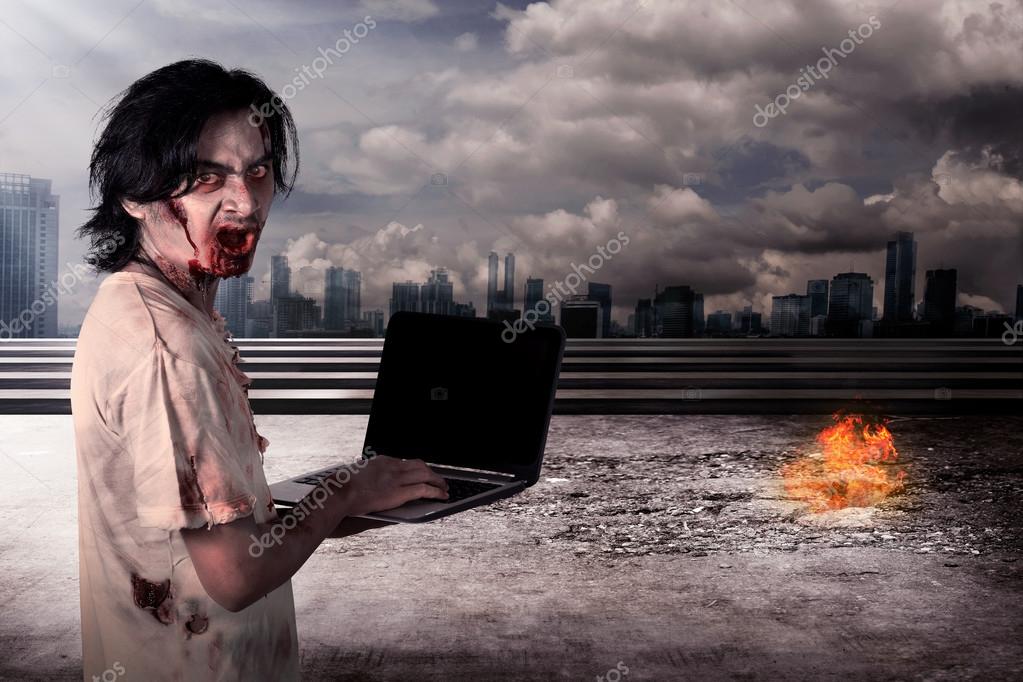 Creepy male zombie typing with laptop Stock Photo by ©leolintang 82824574