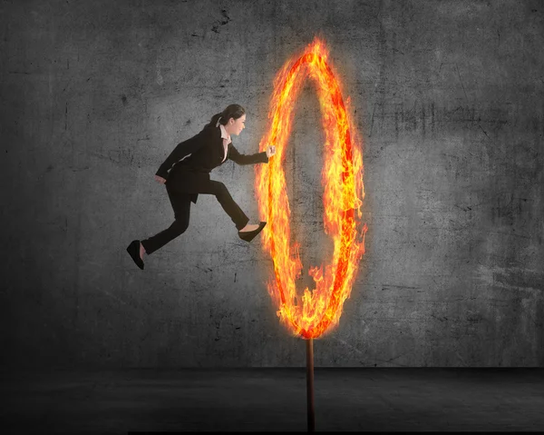 Asian business person jumping through ring of fire - Stock Image ...