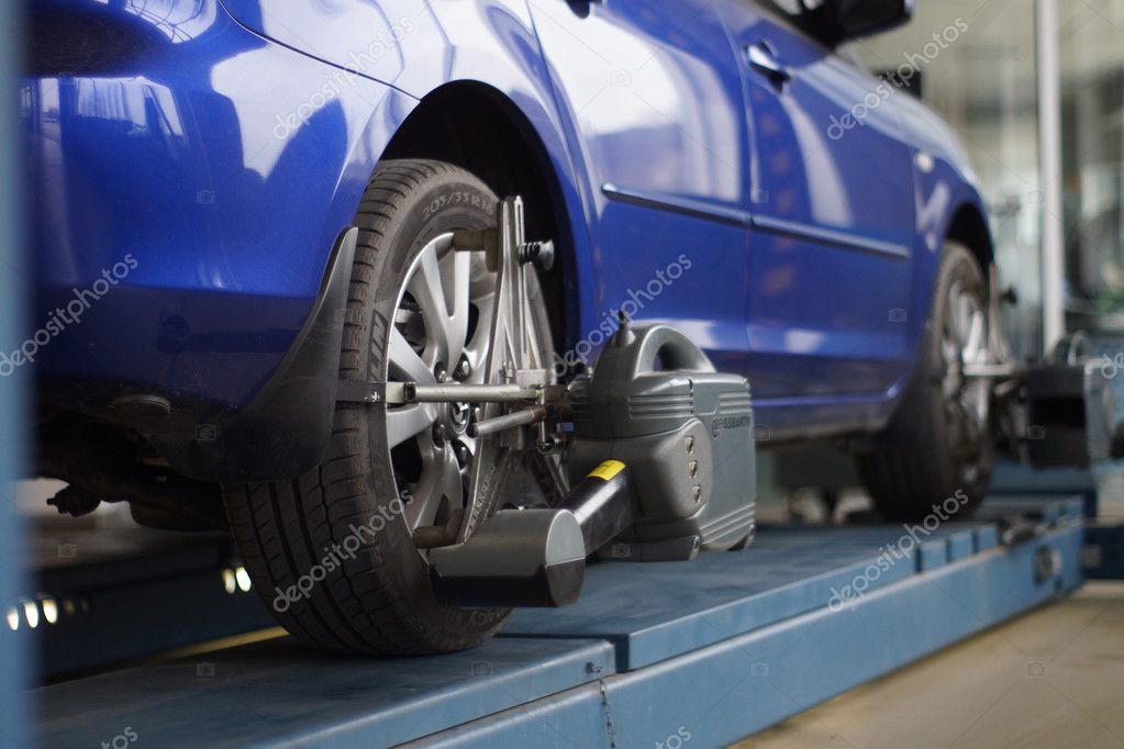 Car on stand with sensors on wheels for wheels alignment camber check ...