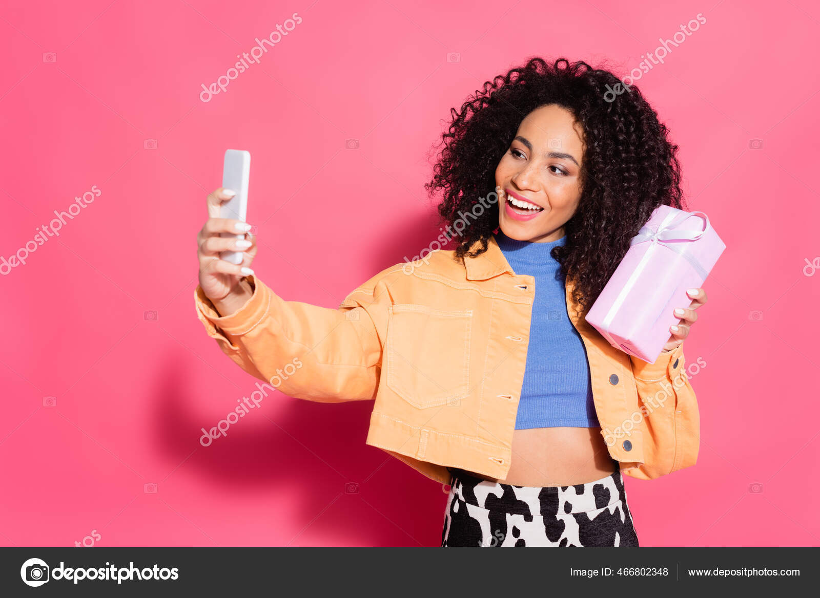 Happy African American Woman Jacket Holding Present While Taking Selfie