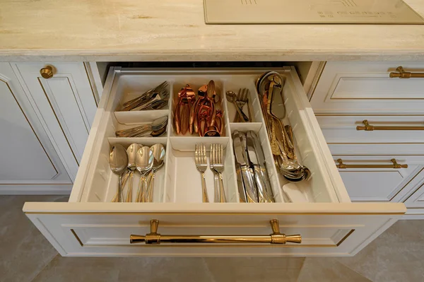 Drawer pulled out in cabinet at luxury beige and gold classic kitchen ...