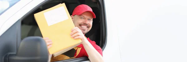 Smiling male courier driver holds mail in his hands - Stock Image ...