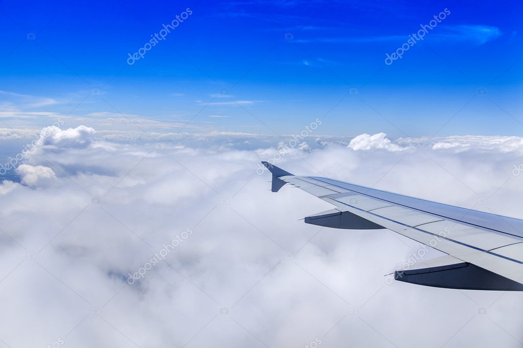Plane view from the window on picturesque white clouds and wing of the ...