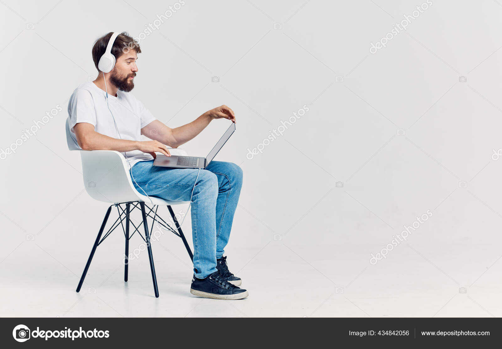 Man sitting on chair in front of laptop in headphones communication ...