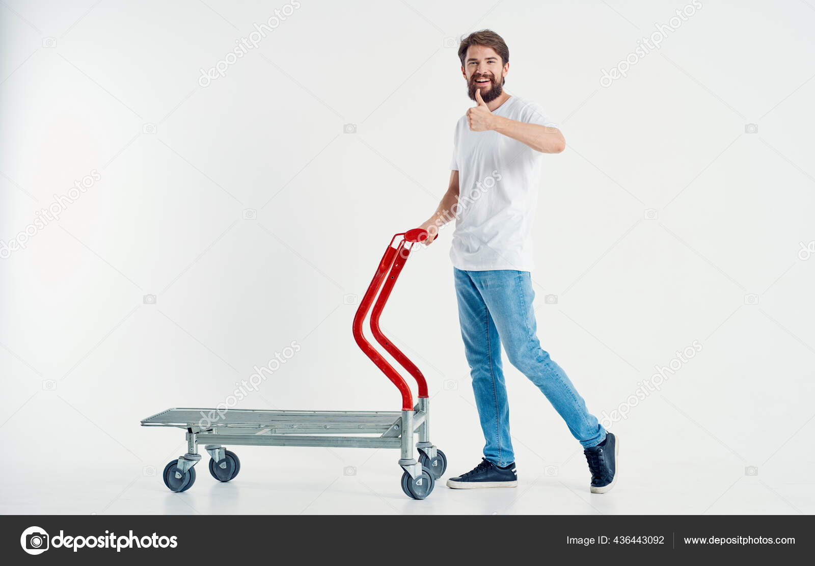 Cargo trolley man in jeans and sneakers light background work ...