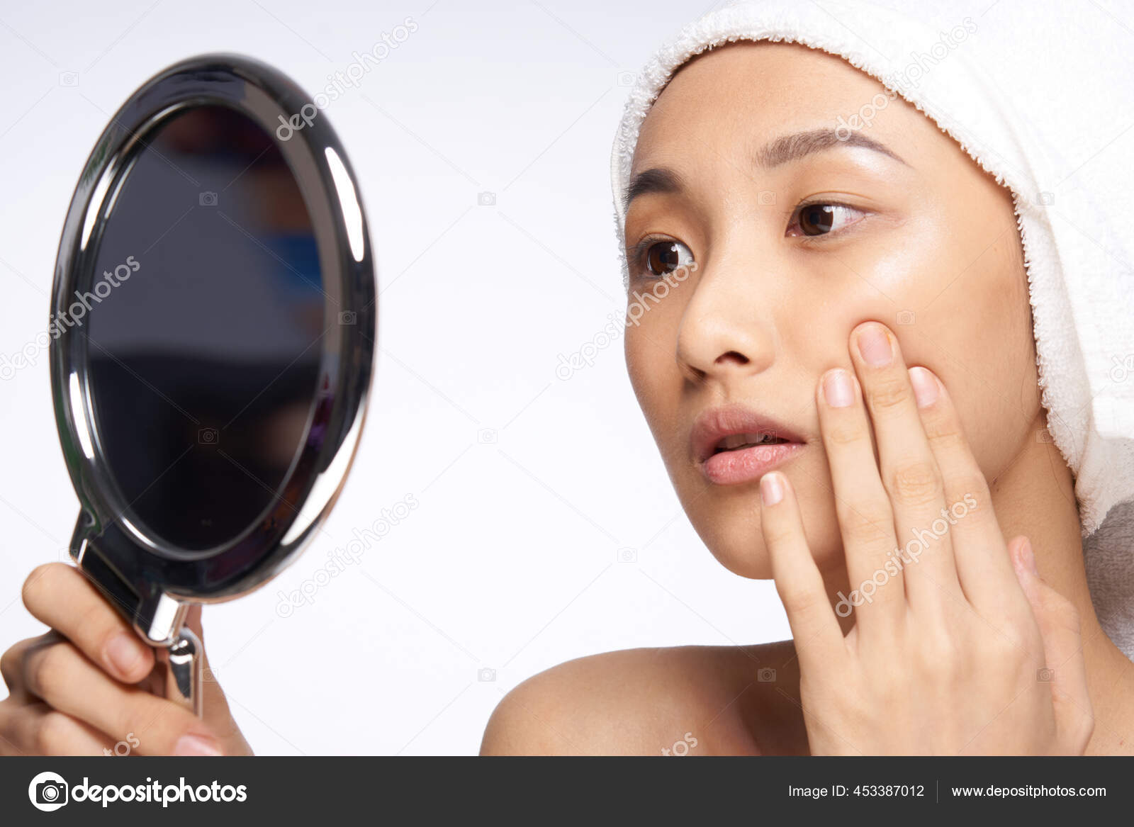 Woman Of Asian Appearance Touches Her Face With Her Hand And Looks In