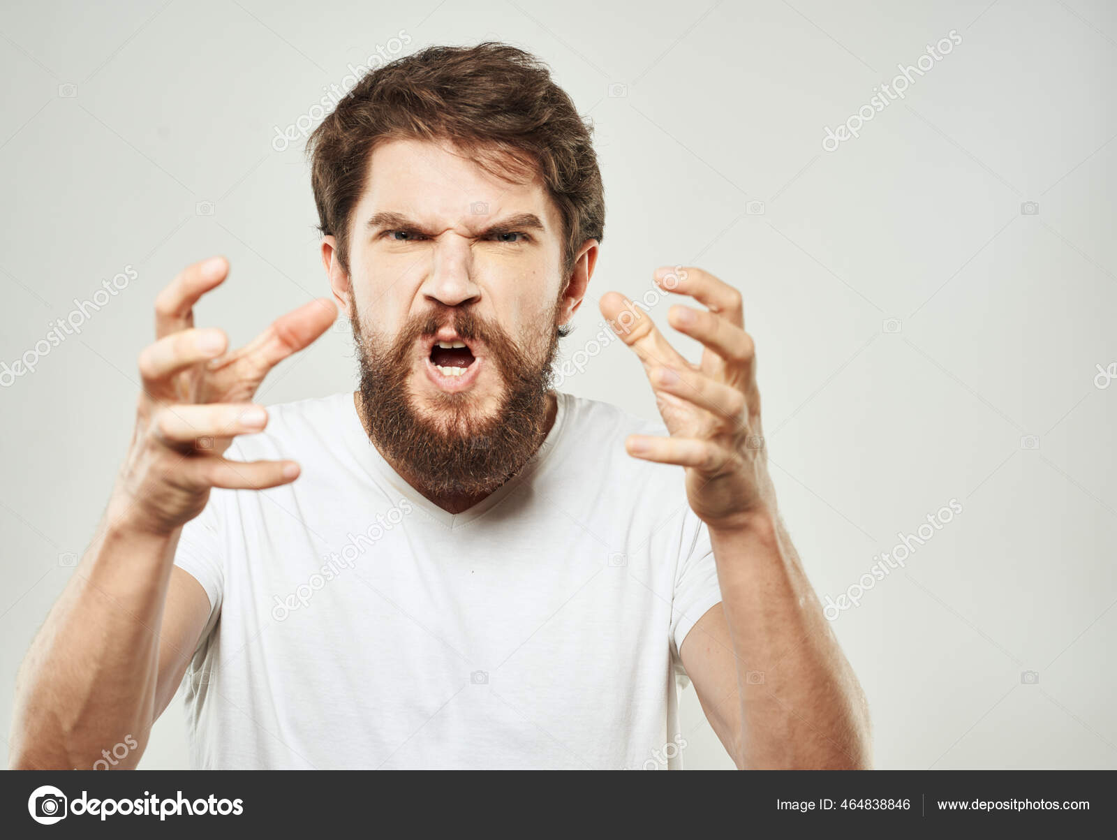 Aggressive man gestures with his hands on a light background stress ...