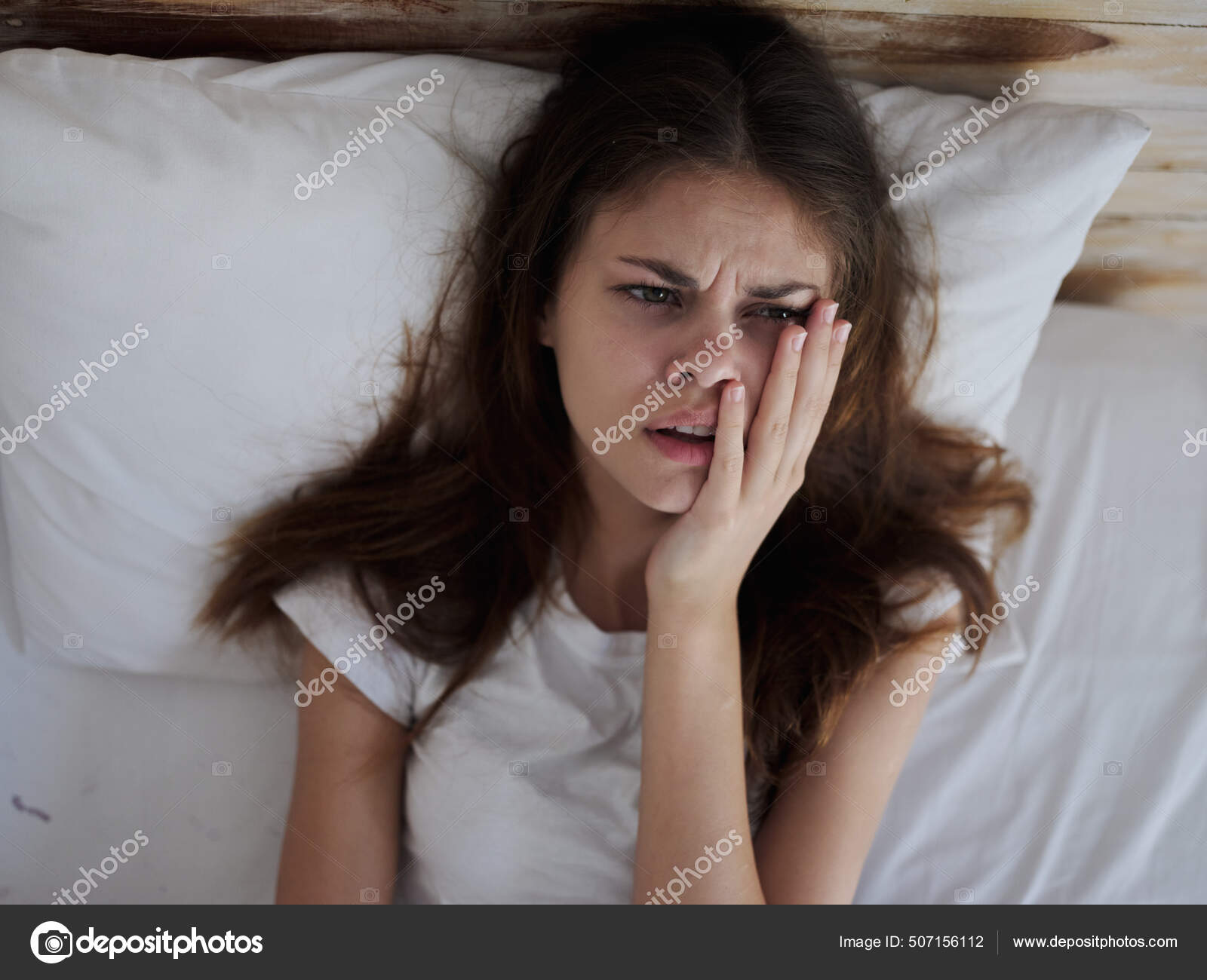 Sick woman lying in bed hand on face discontent Stock Photo by ©ShotStudio 507156112