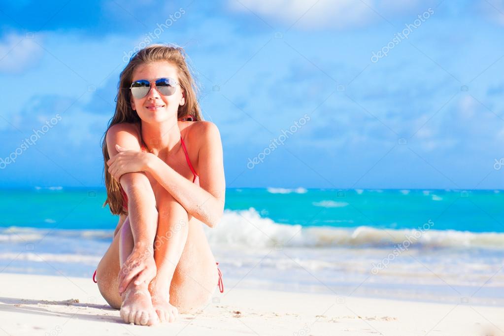 Mujer joven de pelo largo en bikini y gafas de sol en la playa tropical — Foto de stock ...
