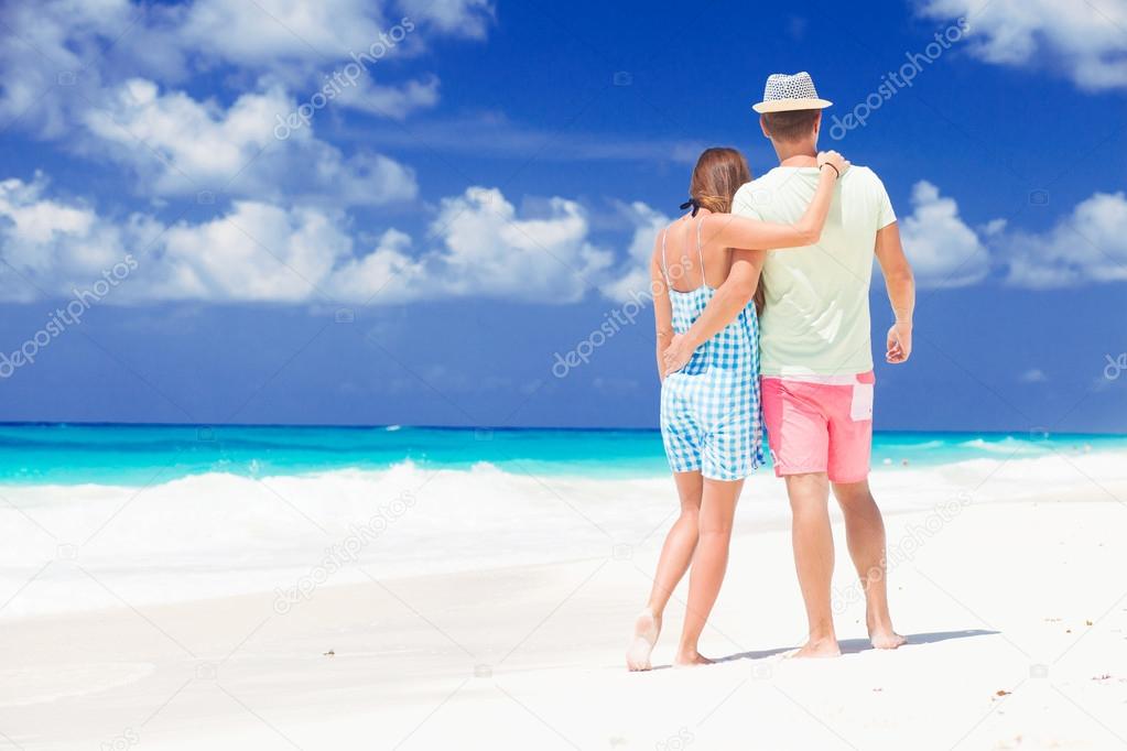 Romantic couple in bright clothes enjoying sunny day at tropical beach ...