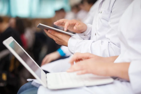 Medical students with pad and laptops in auditorium - Stock Image ...