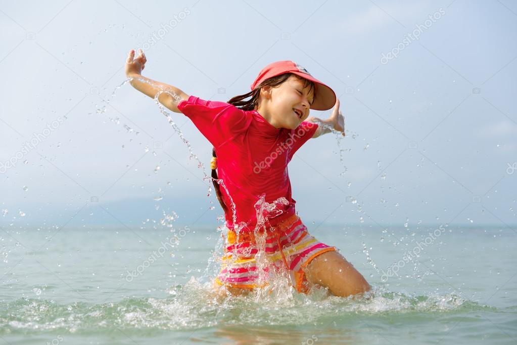 Little girl laughing and crying in the spray of waves at sea — Stock ...