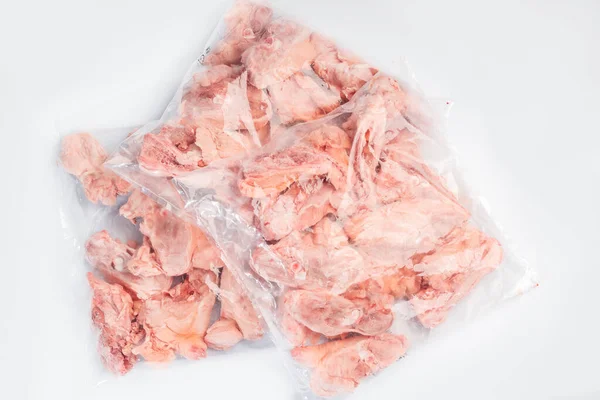 Raw chicken backs in a package packed in a box for delivery on a white ...