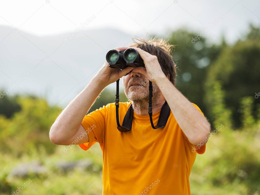 El excursionista hace observación de aves con prismáticos en el parque ...