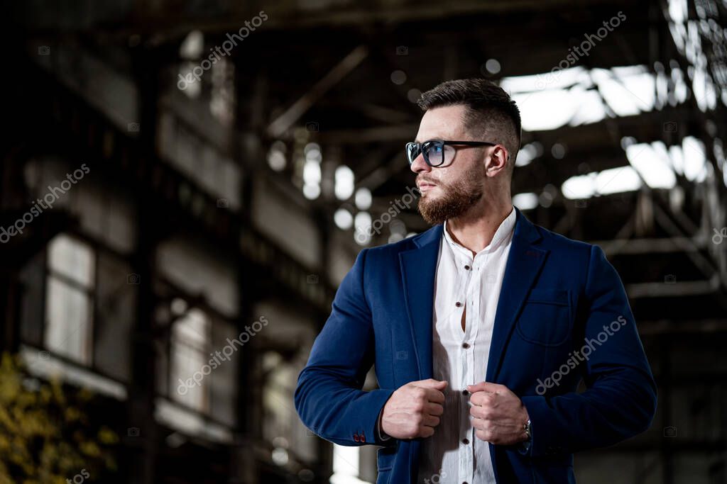 Joven hombre masculino con barba posa sobre viejo edificio roto fondo ... Joven hombre masculino con barba posa sobre viejo edificio roto fondo ...