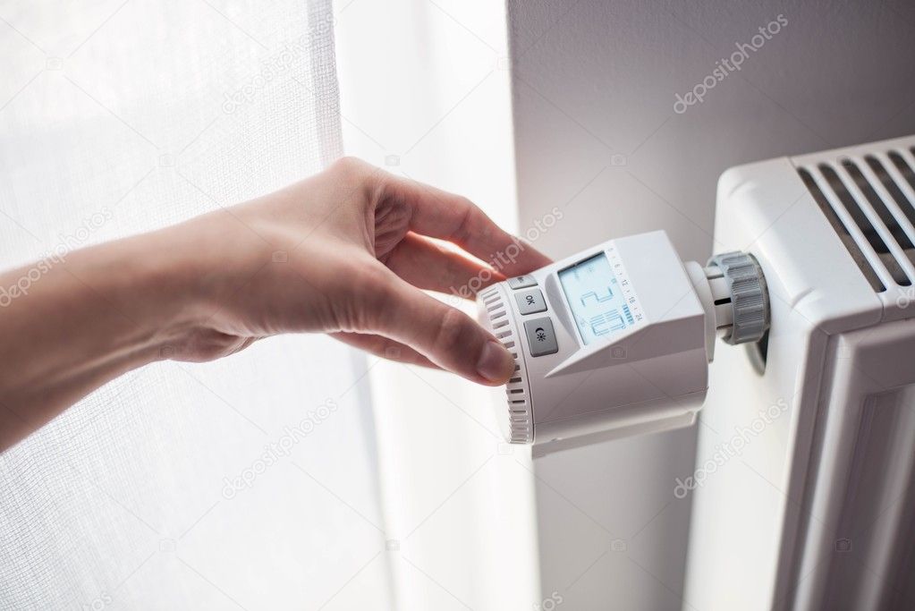 Woman's hand adjusting temperature Stock Photo by ©djedzura 106340872