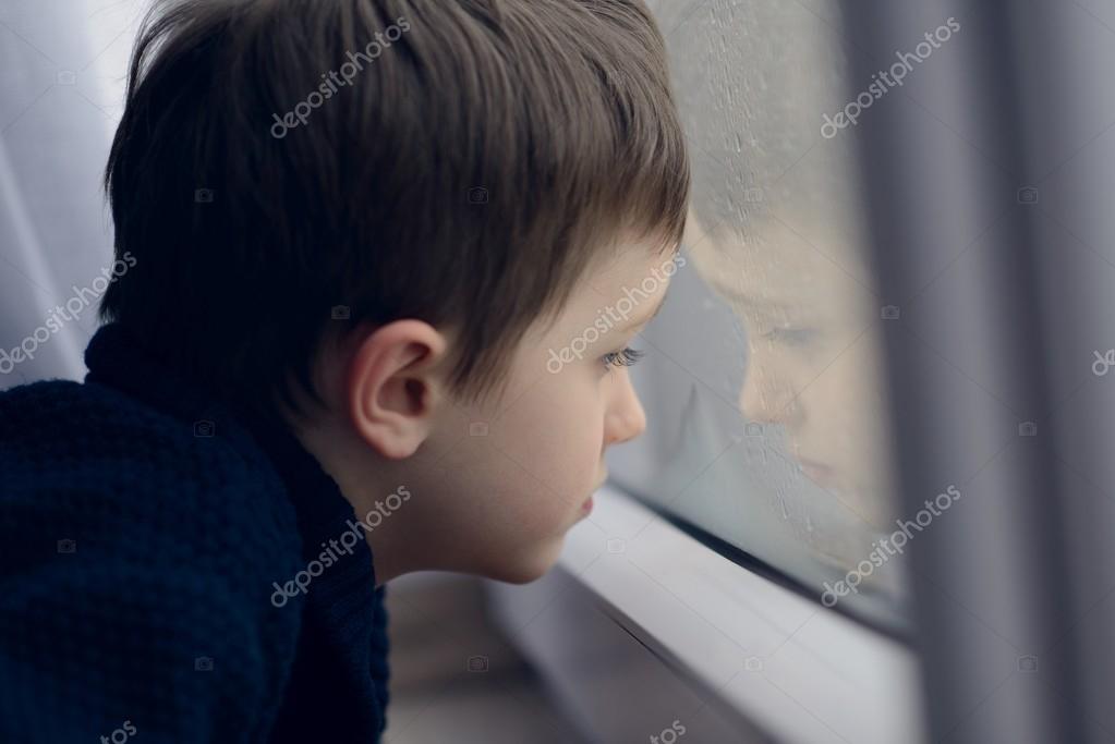 Little boy waiting by window for stop raining. Stock Photo by ©djedzura ...