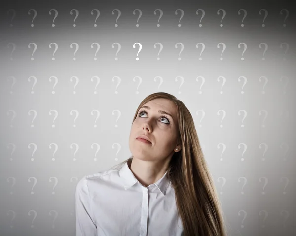 Woman with puzzled face expression and question marks above head ...