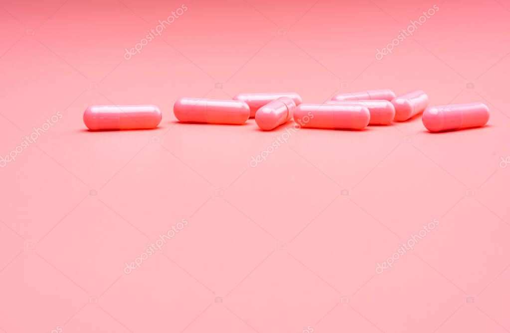 Pastillas de cápsula rosa sobre fondo rosa. Concepto de San Valentín ...
