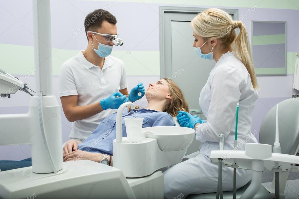 Dentist examining a patients teeth in the dentist. Stock Photo by ...