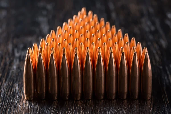 Macro shot of copper bullets that are in many rows to form a tri ...