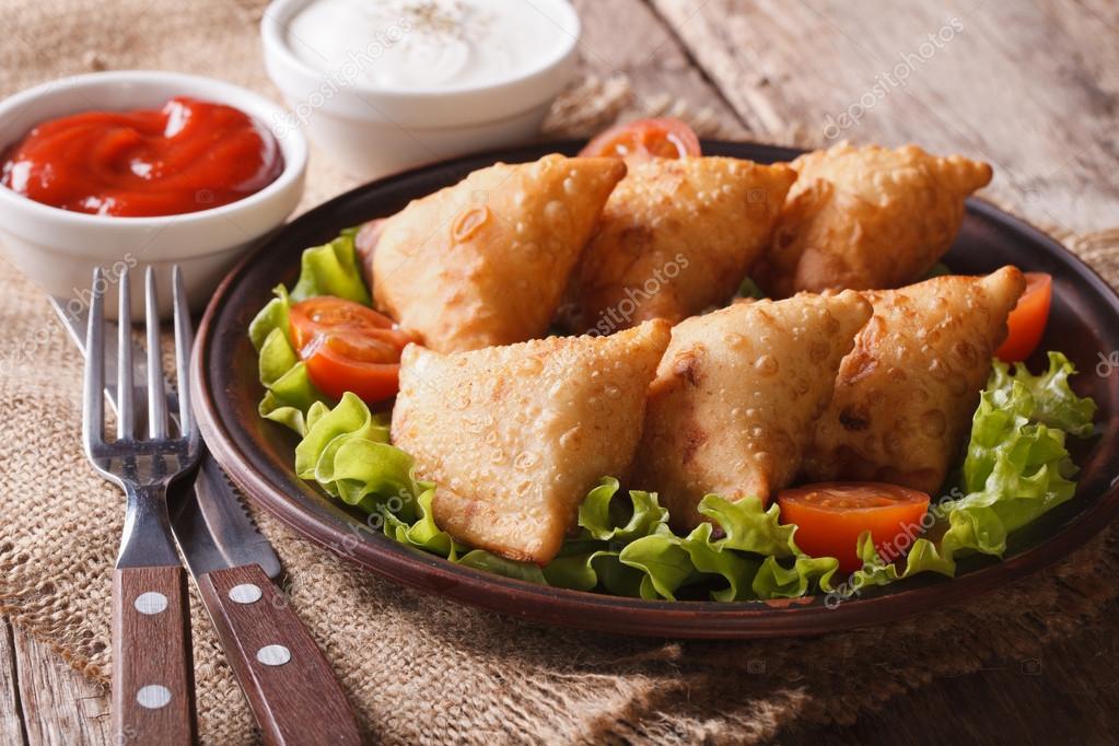 Samosa delicious pastry on a plate with tomatoes and lettuce — Stock ...