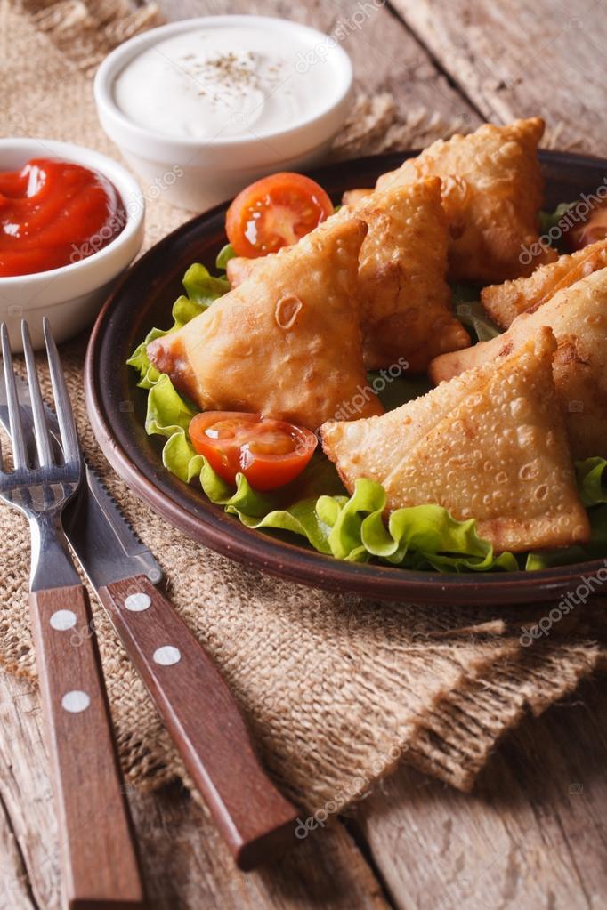 Vegetarian samosas on a plate with tomatoes and lettuce vertical ...