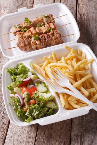 Lunch Box: kebabs, fries and fresh salad in tray close-up. verti ...