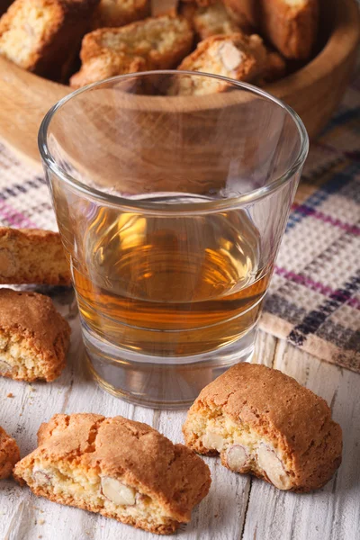 almond biscotti biscuits and sweet wine in a glass closeup. vert ...