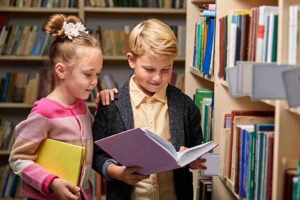 Two cute boy and girl kids reading books in library — Stock Photo ...