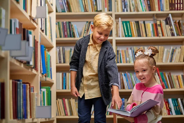 Two cute boy and girl kids reading books in library — Stock Photo ...
