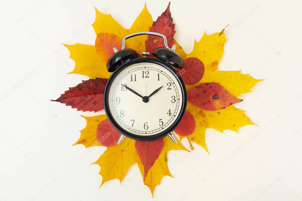 Hola otoño. Fondo de otoño con reloj y hojas sobre fondo blanco. 2022