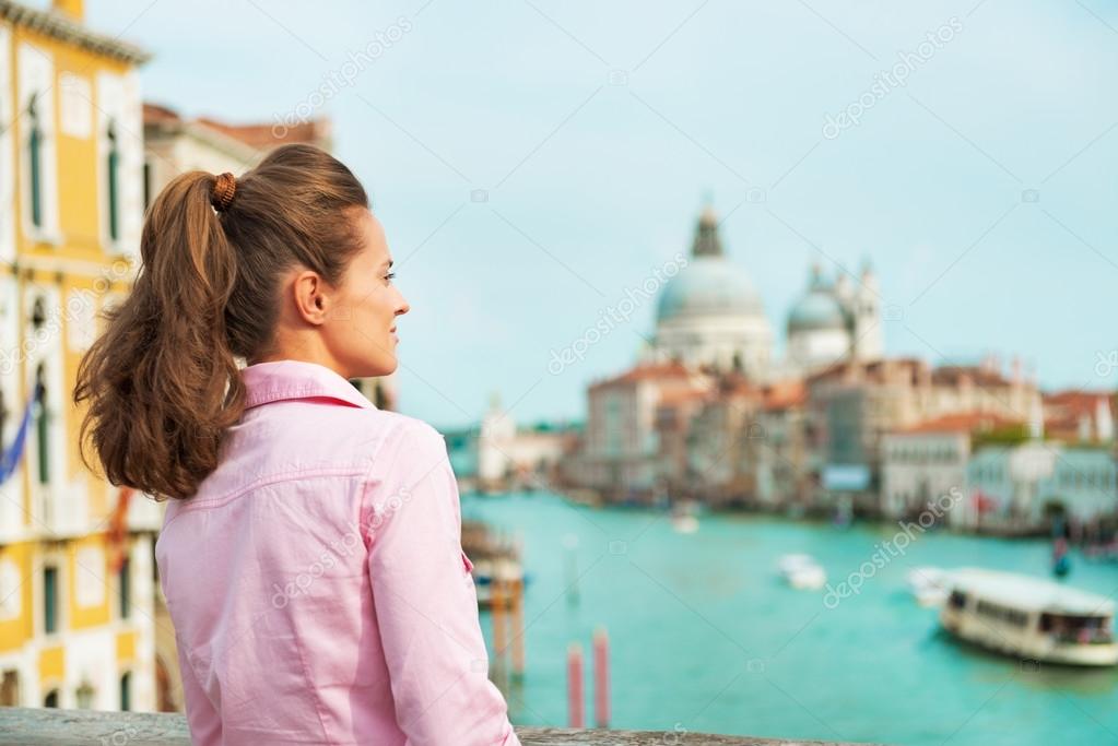 Young woman looking into distance while standing on bridge with — Stock ...