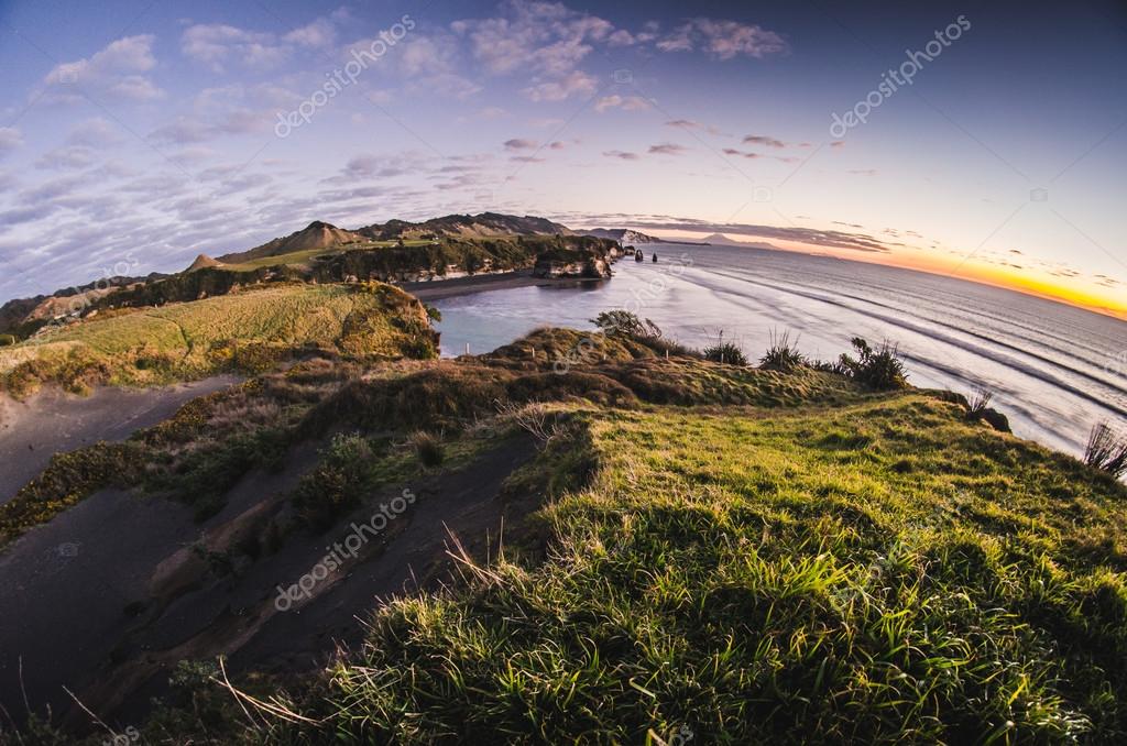 Sunset over sea shore rocks and mount Taranaki, New Zealand — Stock ...
