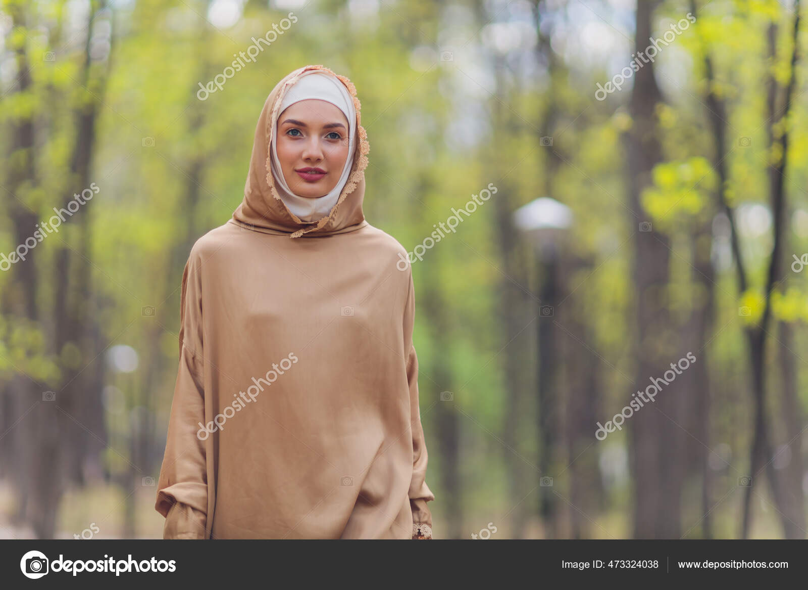 Mujer hermosa islámica en un vestido musulmán de pie en un parque de ...