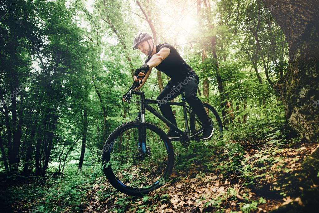 Professional mountain bike cyclist riding trail in forest, details of ...