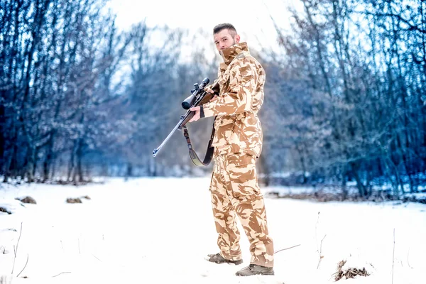 Army sniper during military operation using a professional rifle on a ...