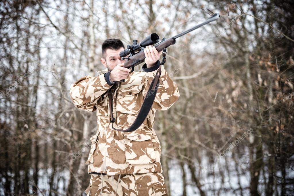 Sniper with weapon ready for combat or hunting in the forest on a ...