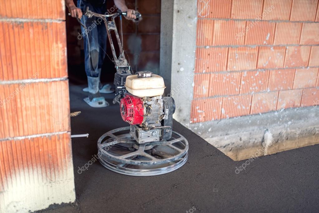 Cement smoothing trowel machinery with worker. flooring smoothing at ...
