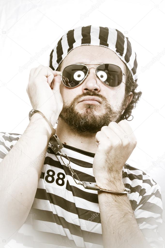 Prisoner in prison garb posing — Stock Photo © outsiderzone #78832220