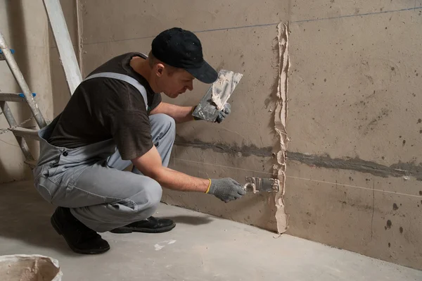 Worker gets plaster on the wall - Stock Image - Everypixel